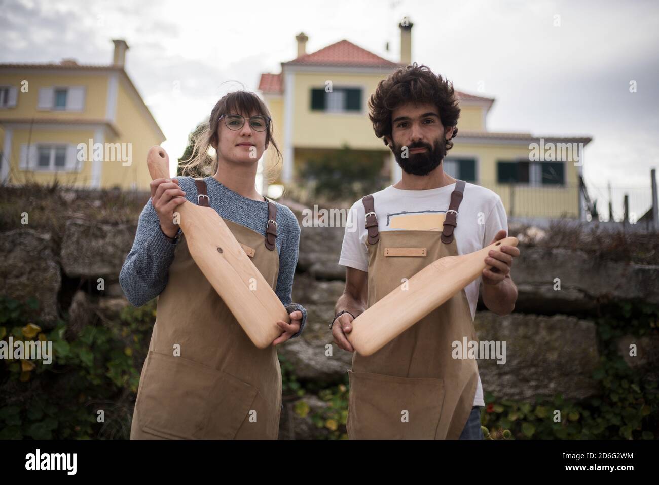 A young couple of carpenters working together in a small carpentry ...