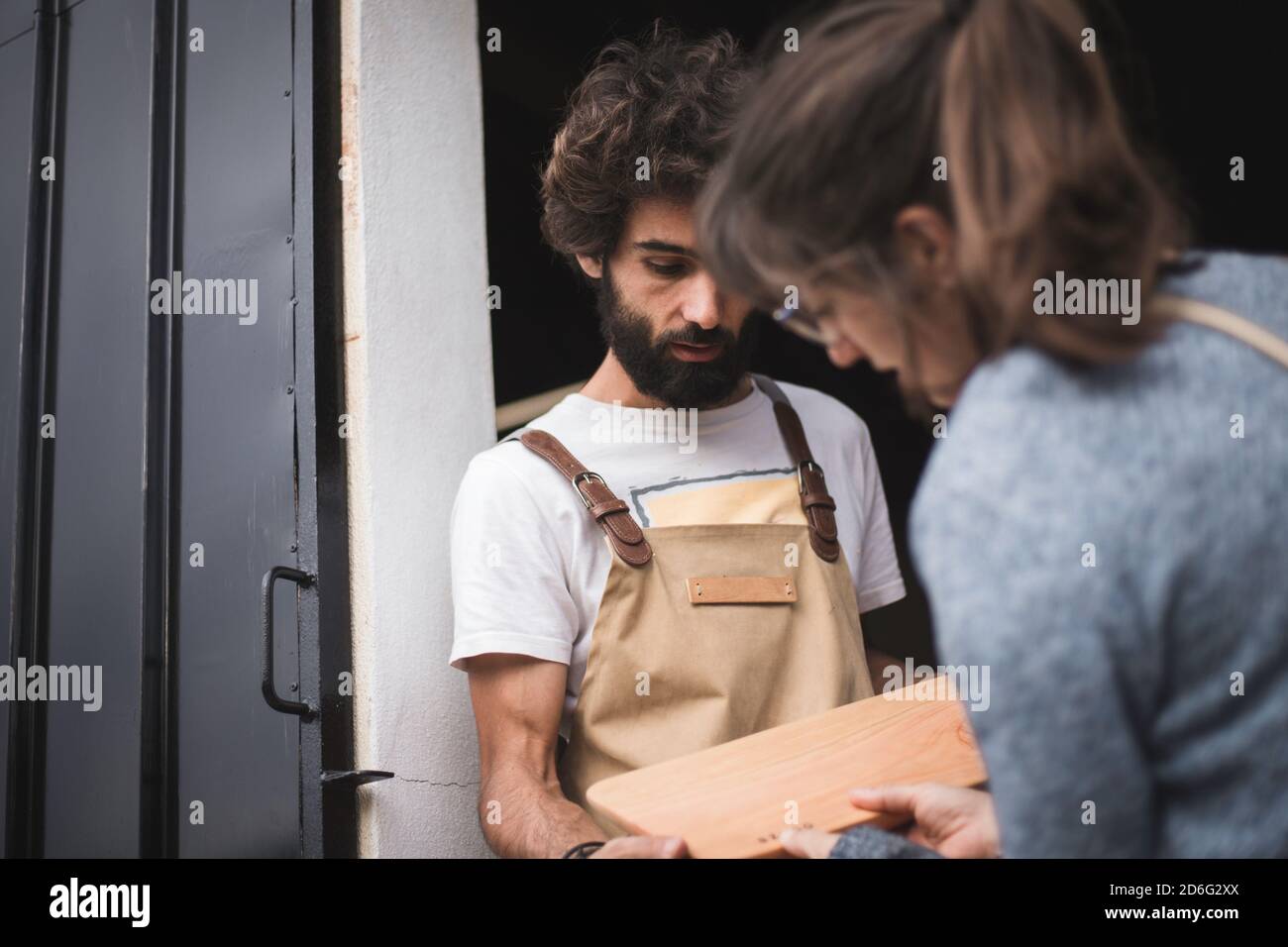 A young couple of carpenters working together in a small carpentry ...