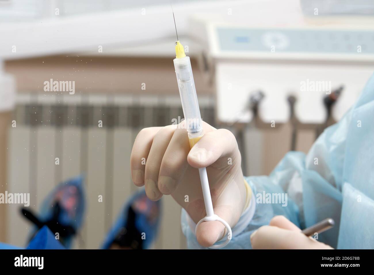Hand of dentist holding dental syringe Stock Photo - Alamy