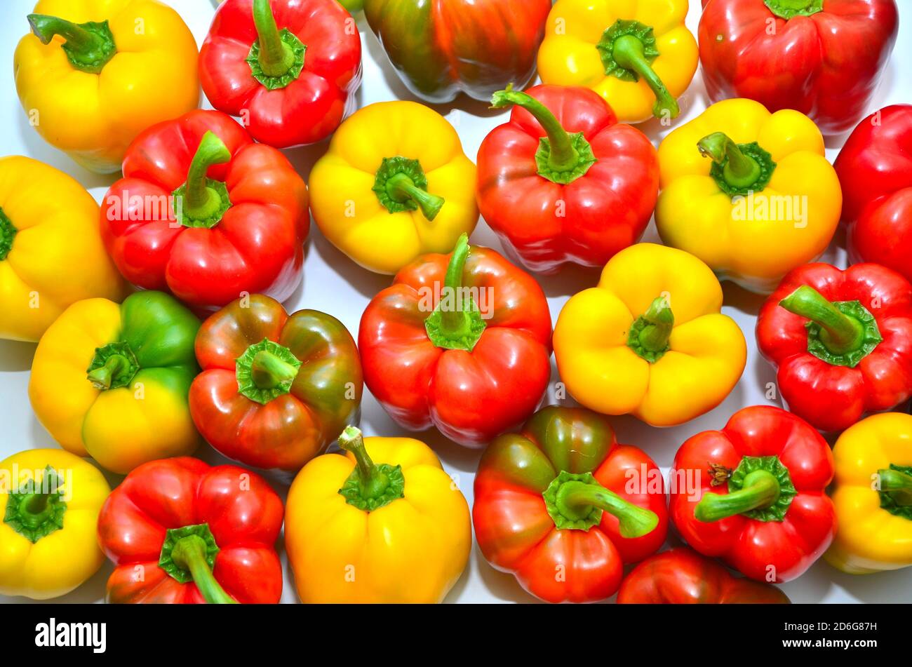 red and yellow paprikas on a white background Stock Photo - Alamy