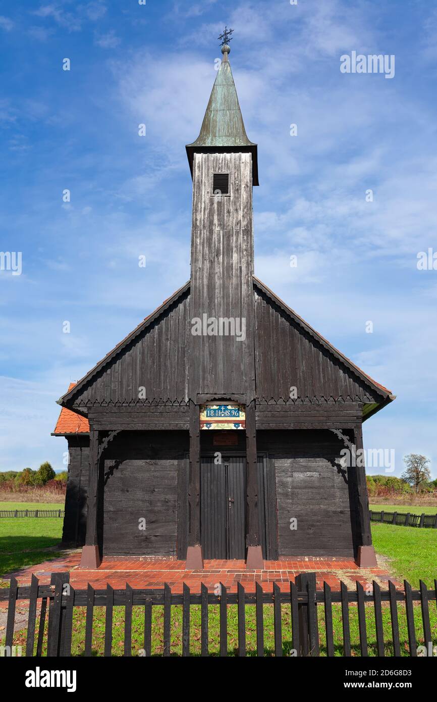 Black wooden church with small bell tower and black picket fence in ...