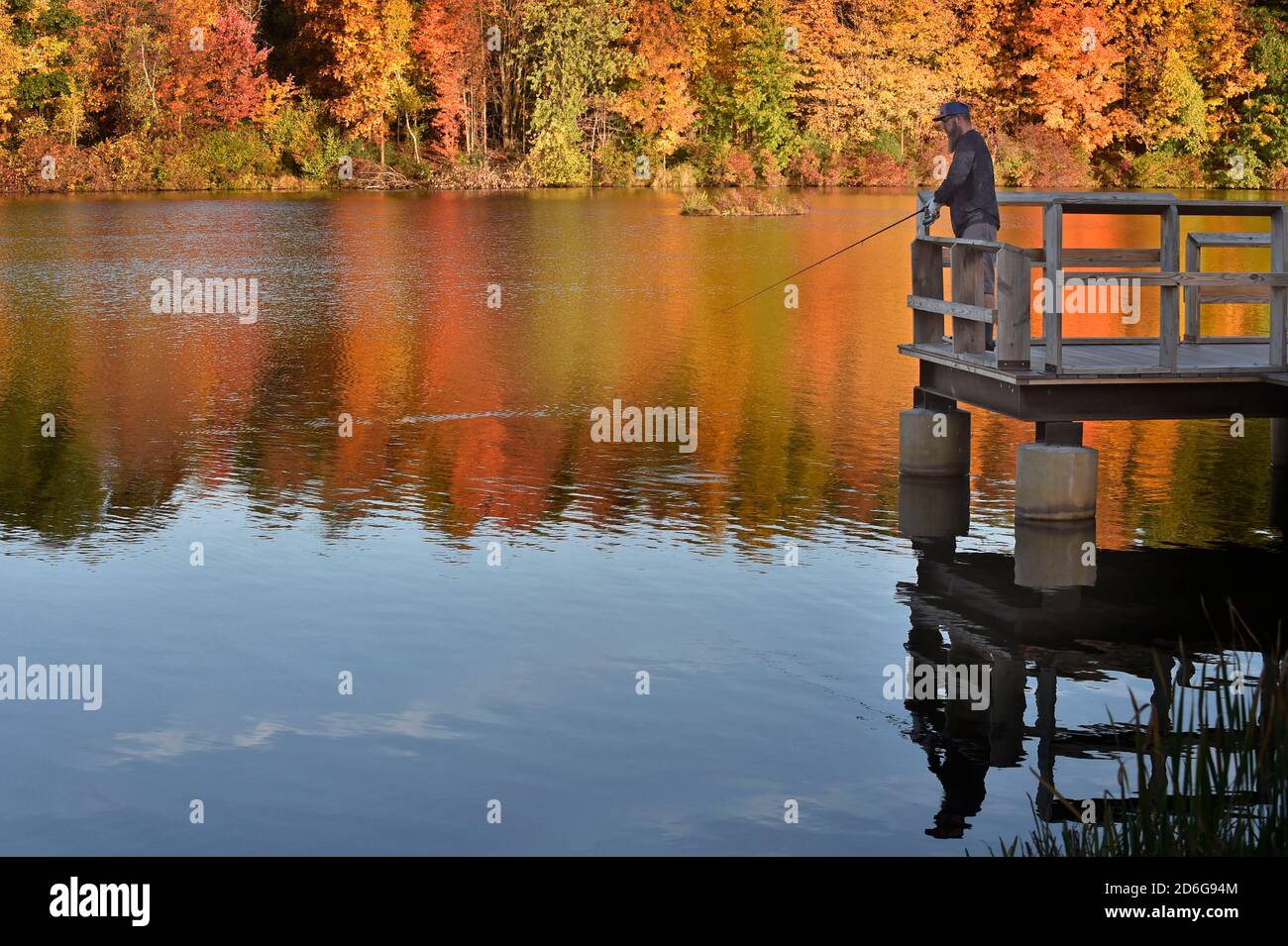 A fisherman is reflected in Lake Frances at Frances Slocum State Park ...