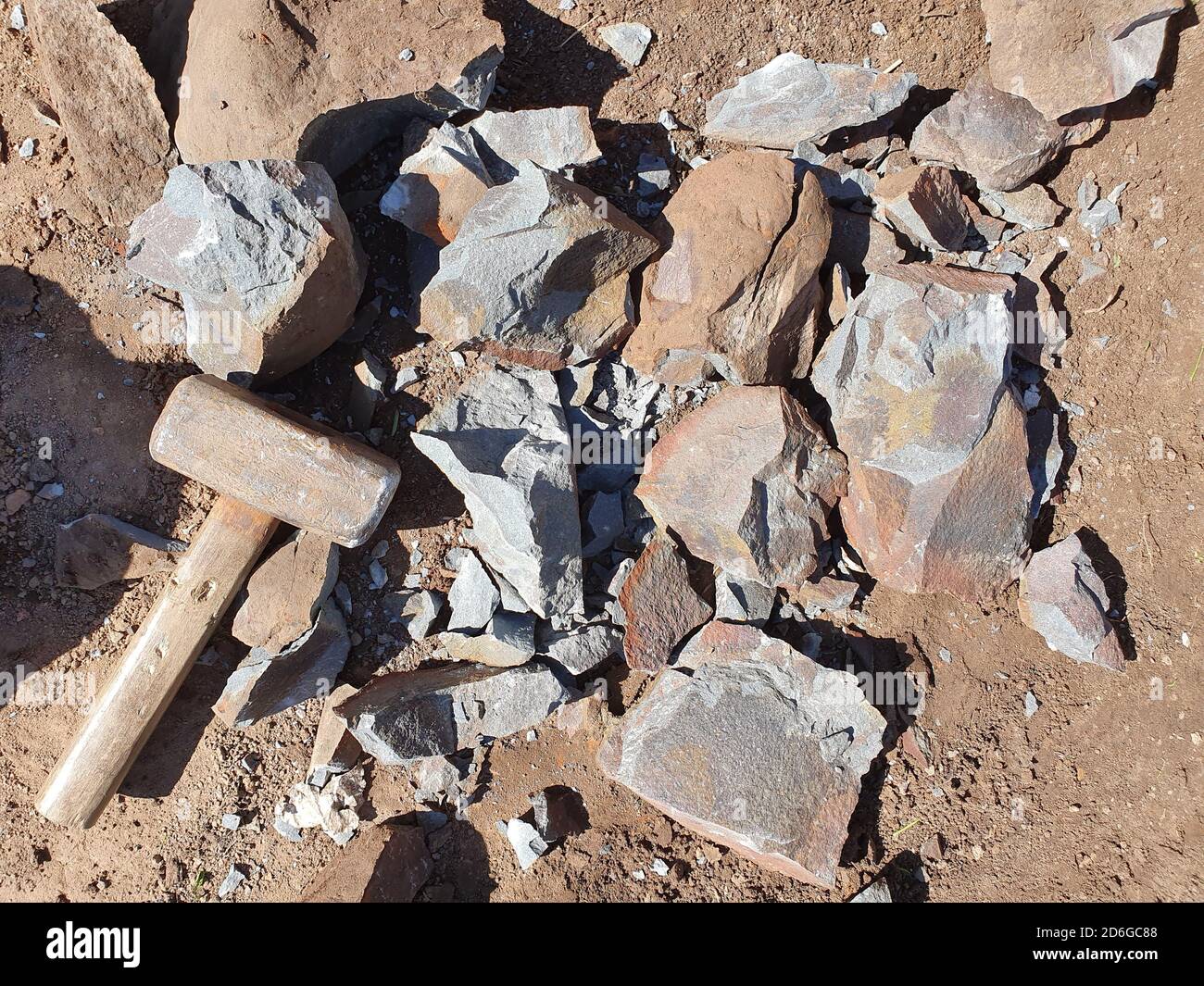 The hammer and chipped stones lie side by side. The hammer was used as ...