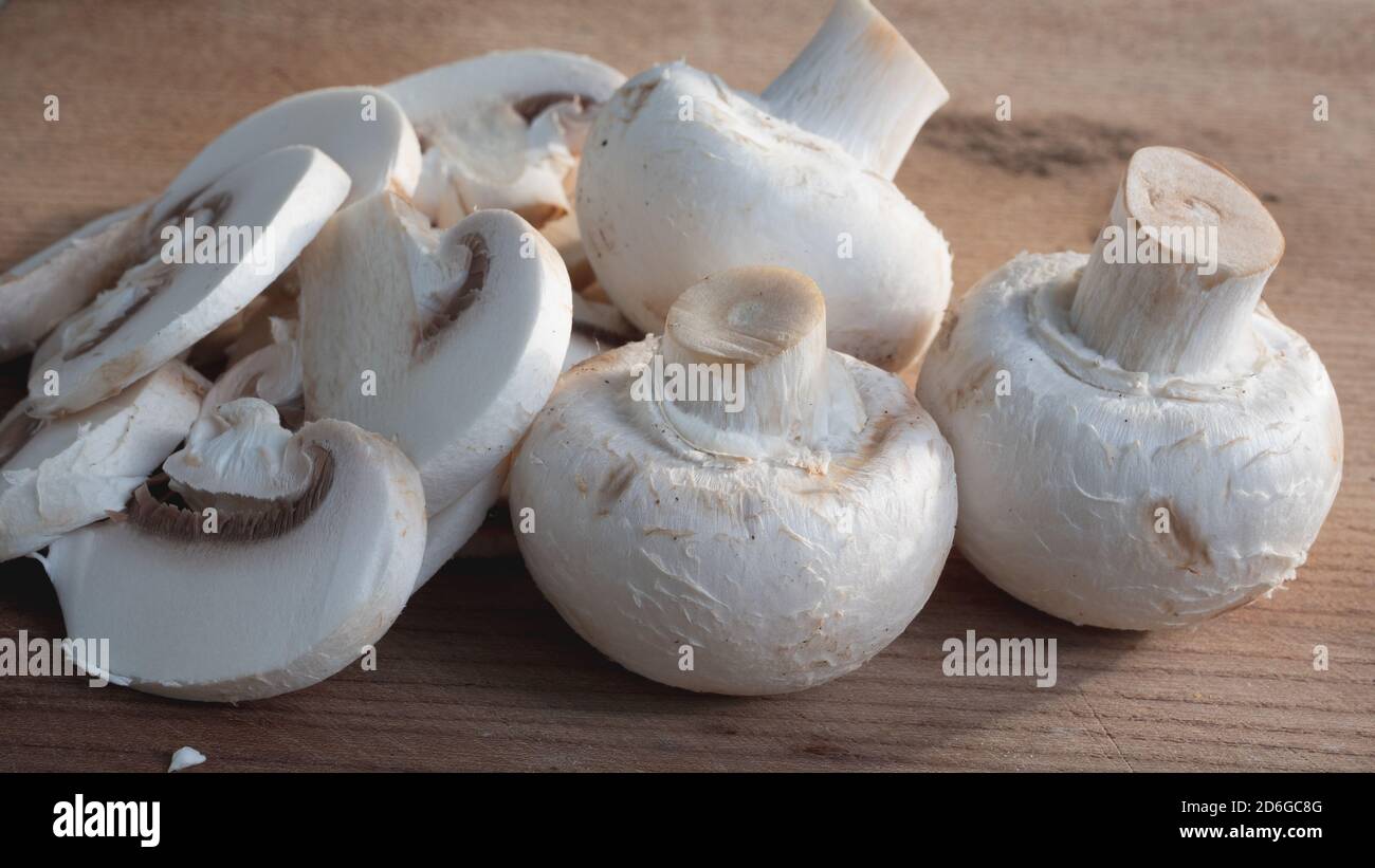 Fluffy bright white mushroom in great close up on wooden cutting board ...