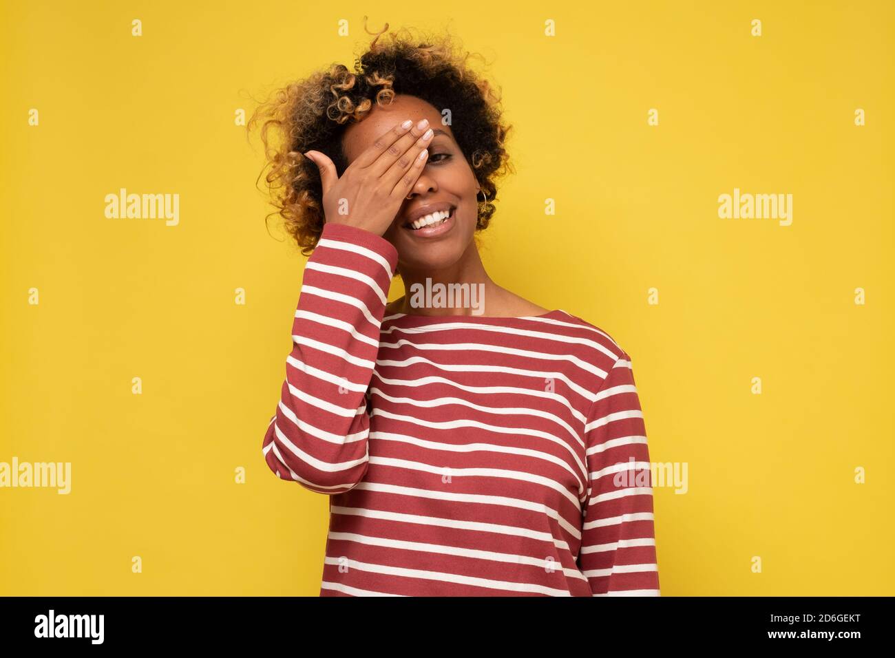 Young african woman closing one eye with her hand smiling during optic ... Young african woman closing one eye with her hand smiling during optic ...