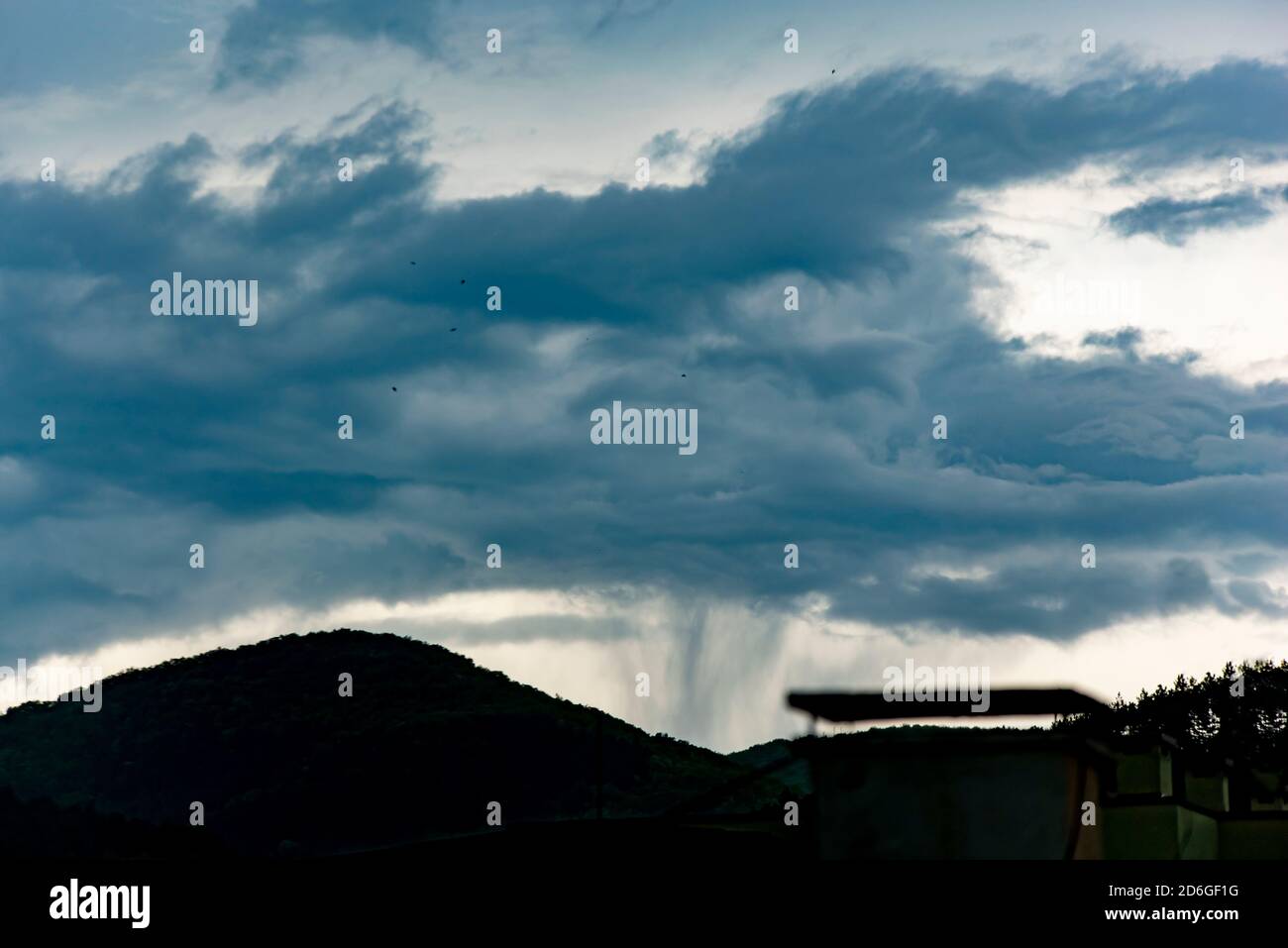 Rain pouring from a huge storm cloud in the distance Stock Photo - Alamy