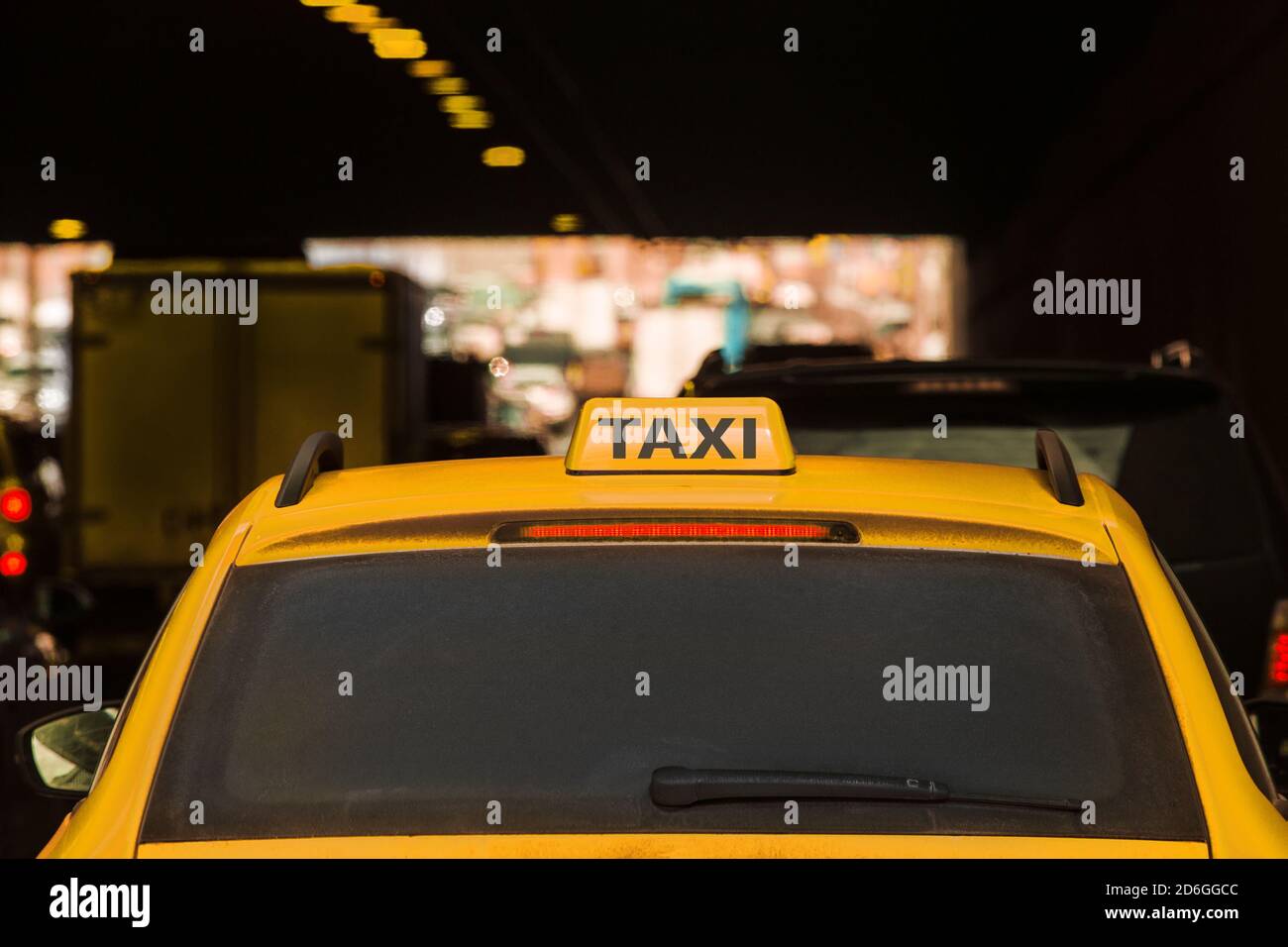 Yellow taxi moves in the midst of cars along city streets at night ...