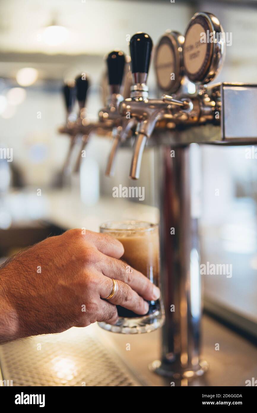 Bartender hand pouring beer from a tap Stock Photo - Alamy