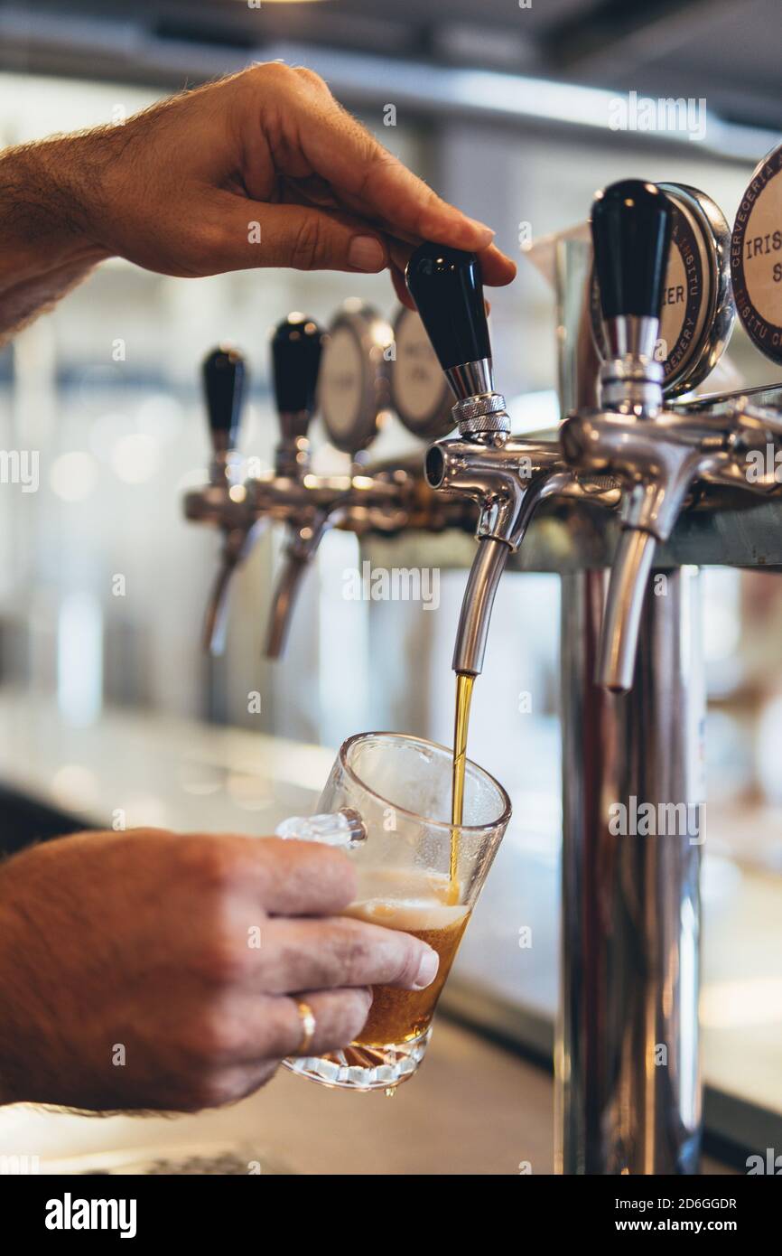 Bartender hand pouring beer from a tap Stock Photo - Alamy