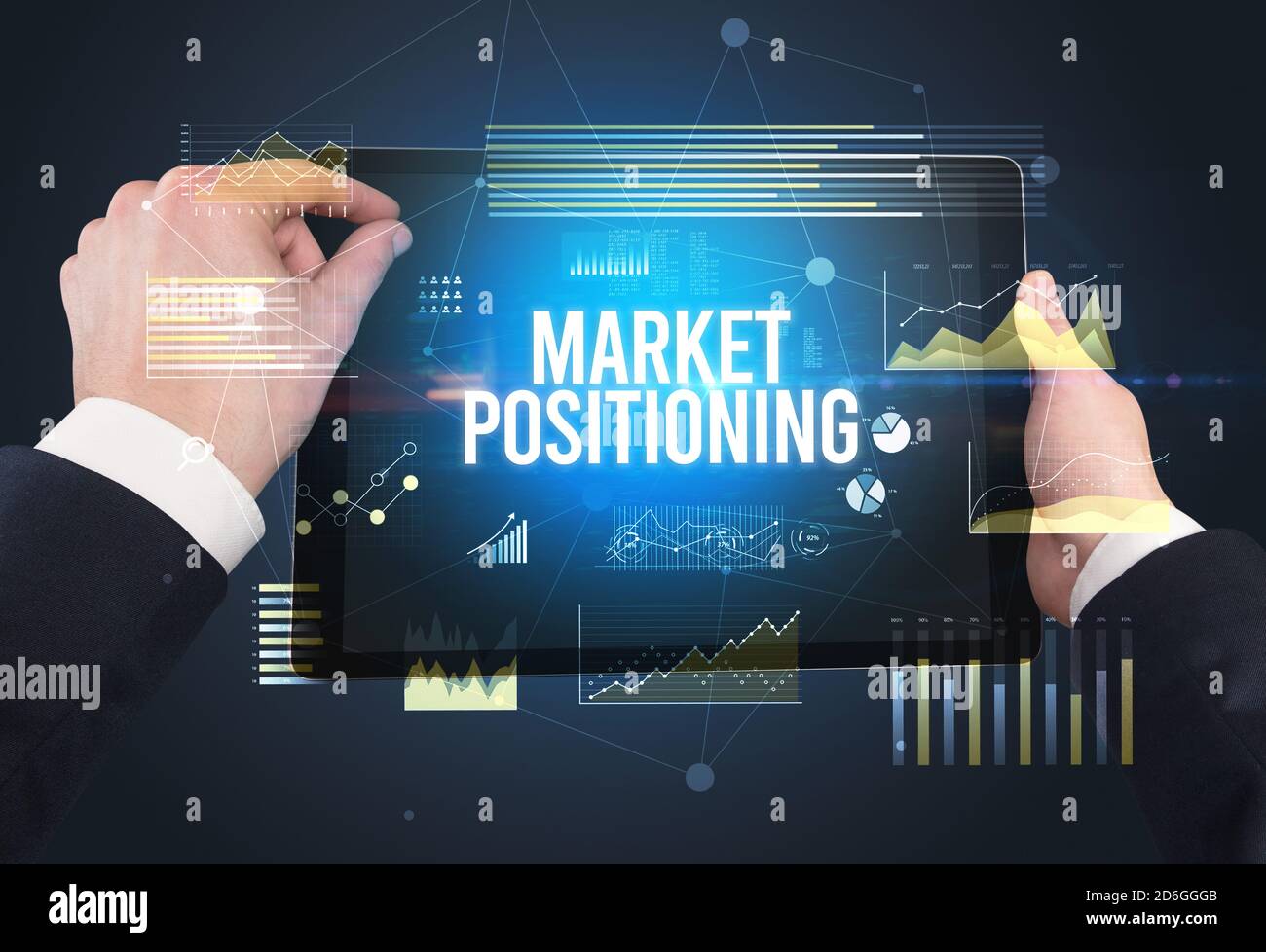 Close-up of hands holding tablet with MARKET POSITIONING inscription ...