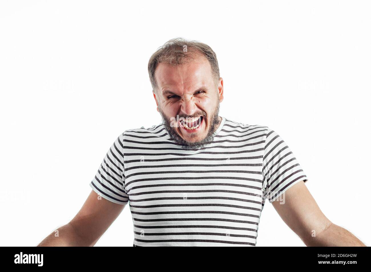 Angry screaming bearded adult rage man in a striped T-shirt. 30-35 ...