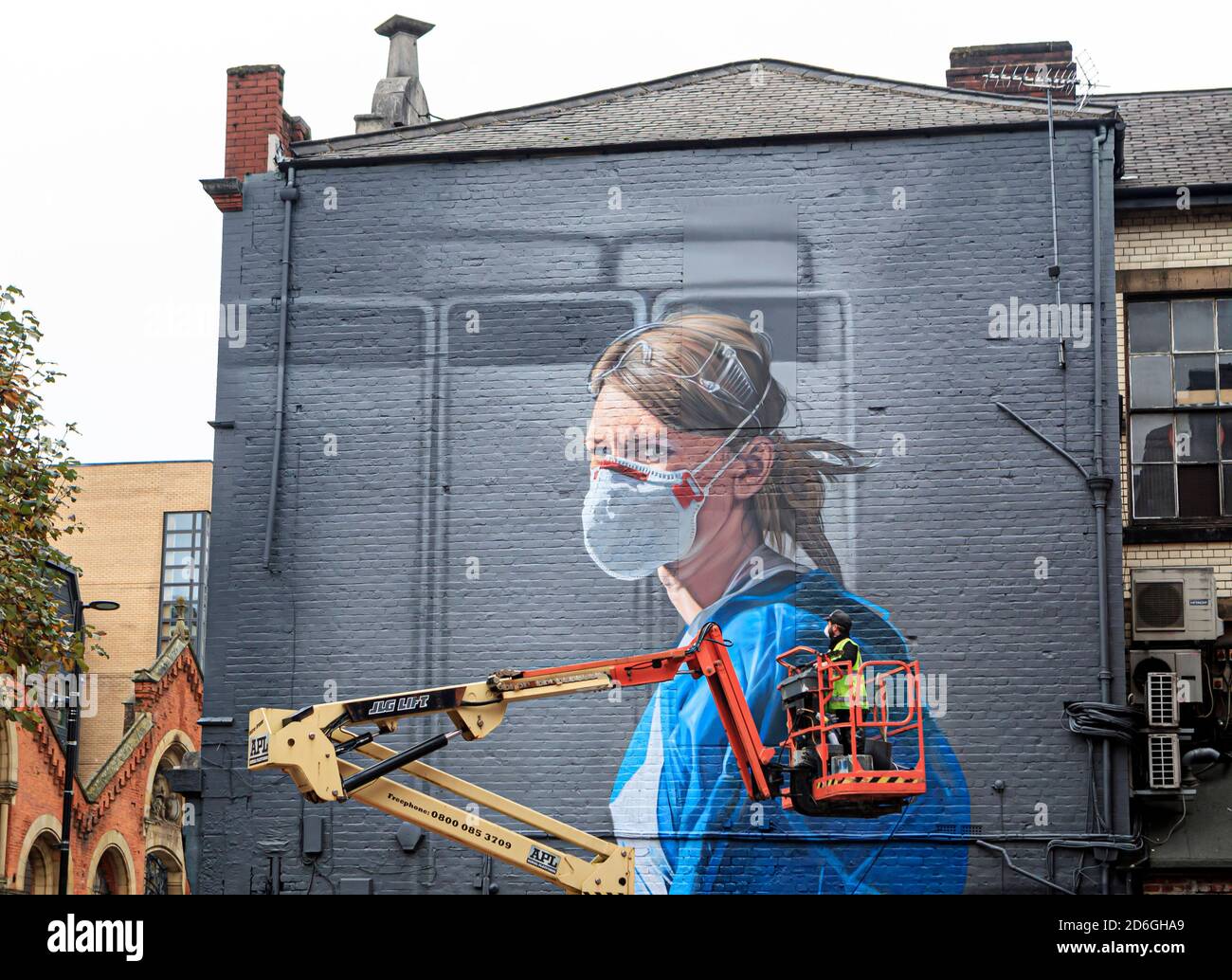 Artist Peter Barber works on a mural in Manchester city centre ...