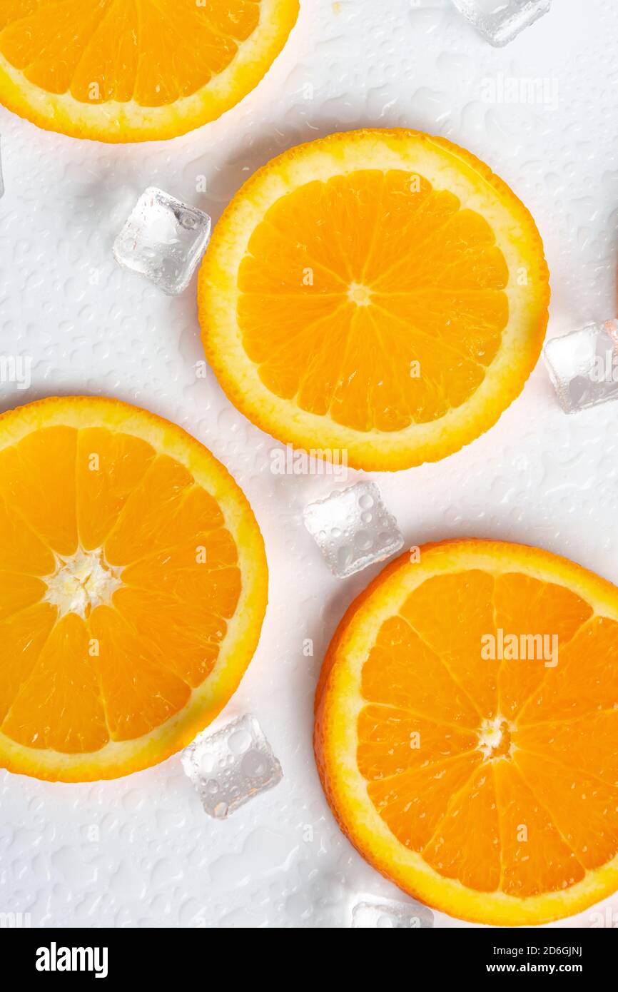 slices of orange with ice on a white background Stock Photo - Alamy