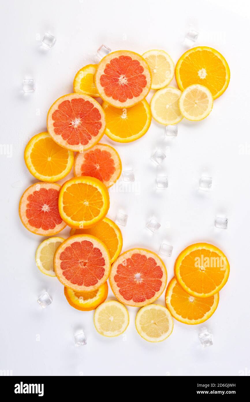 slices of grapefruit orange and lemon forming a letter c on a white ...