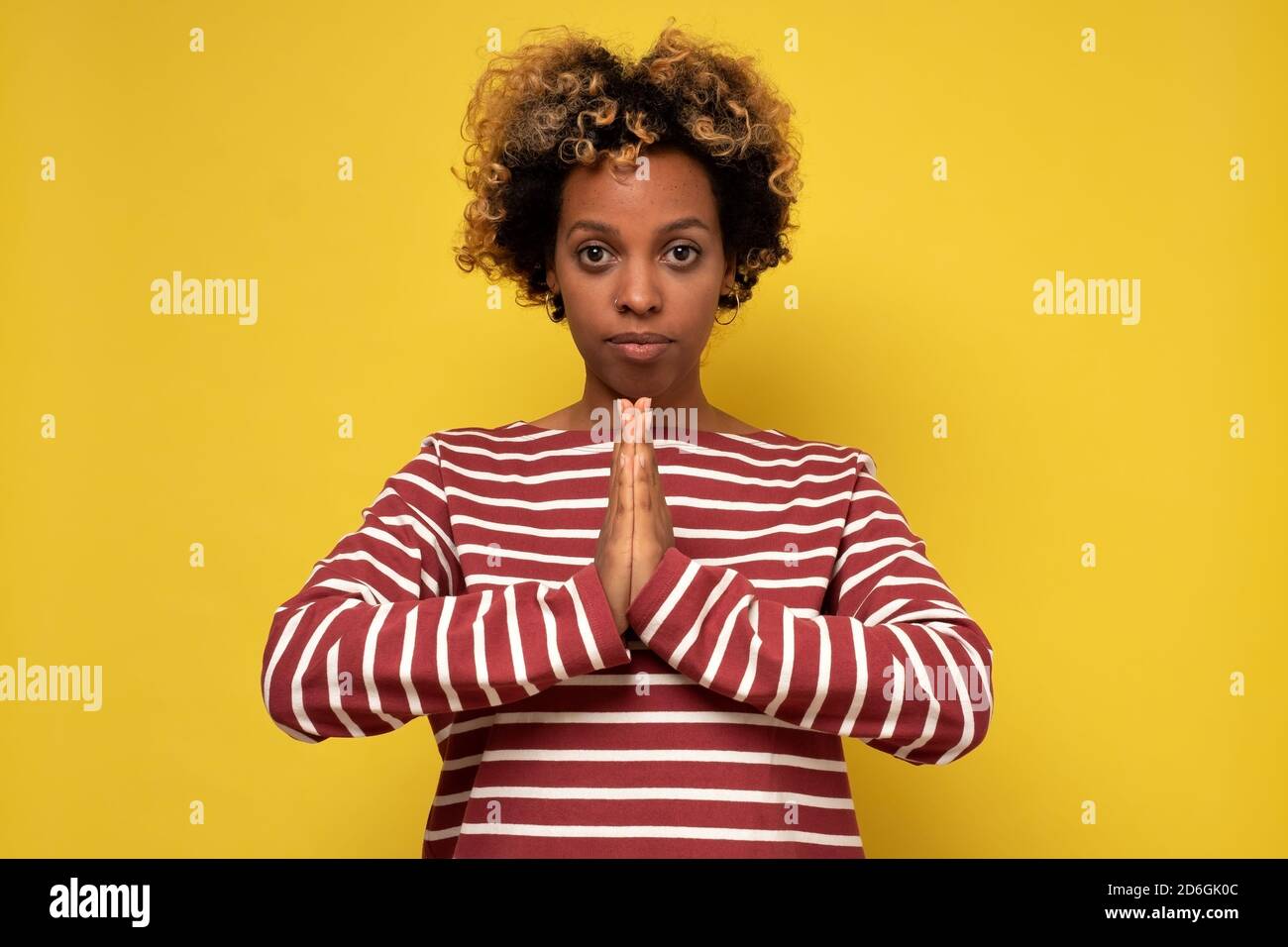 Woman practising yoga calming down release stress, press palms together ...