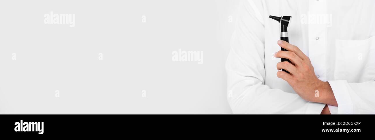 Web banner, an audiologist with otoscope on grey background. Ear ...