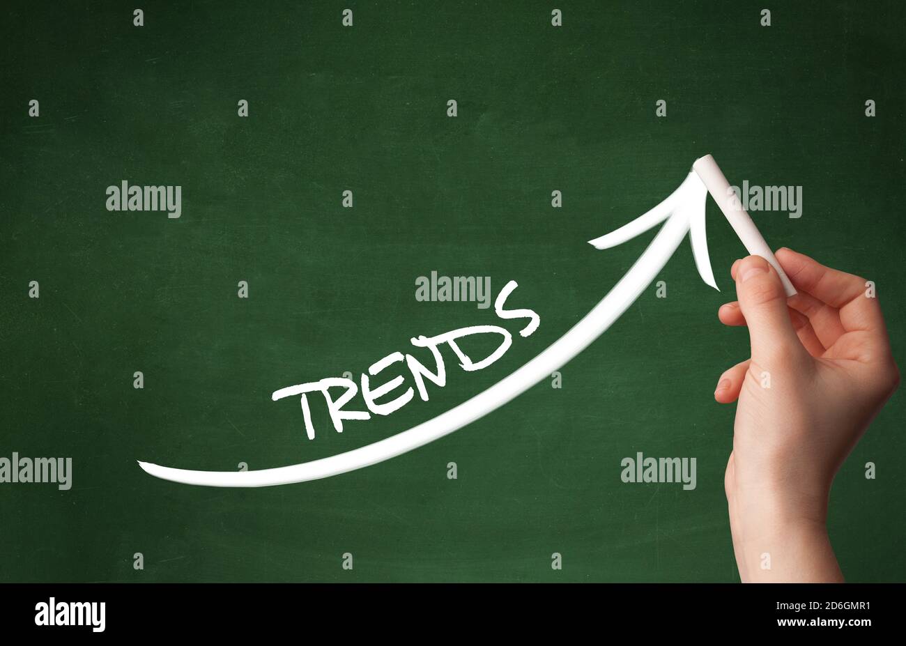 Hand drawing TRENDS inscription with white chalk on blackboard ...