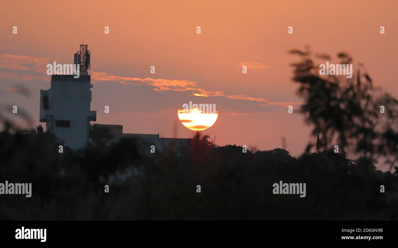 Round the big sun passing through the orange colored clouds at sunrise ...