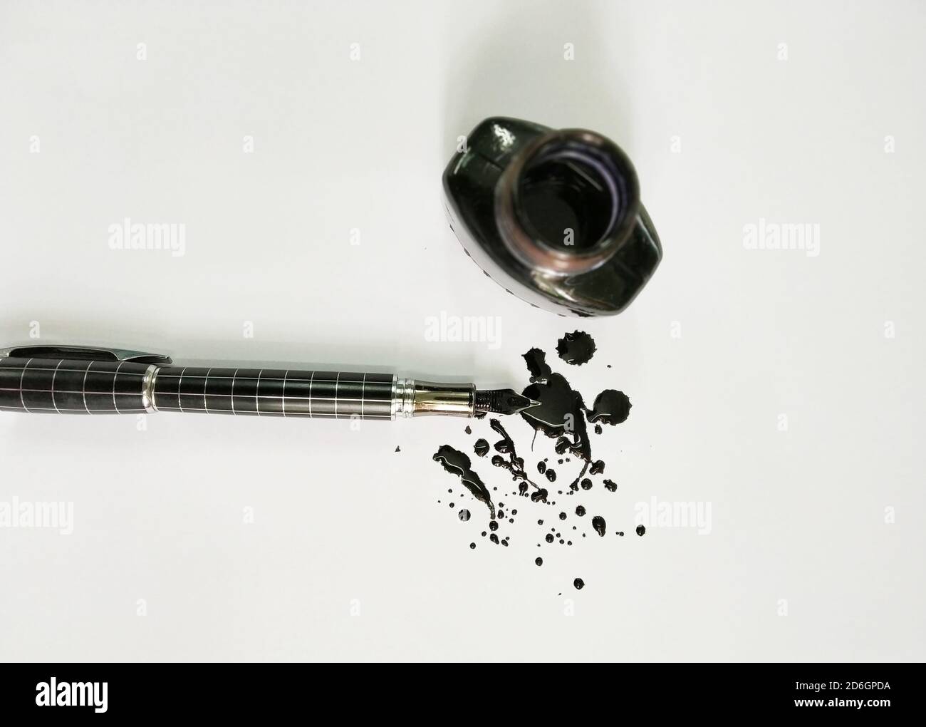 A Ink pen with black ink spread on paper and a ink bottle Stock Photo ...