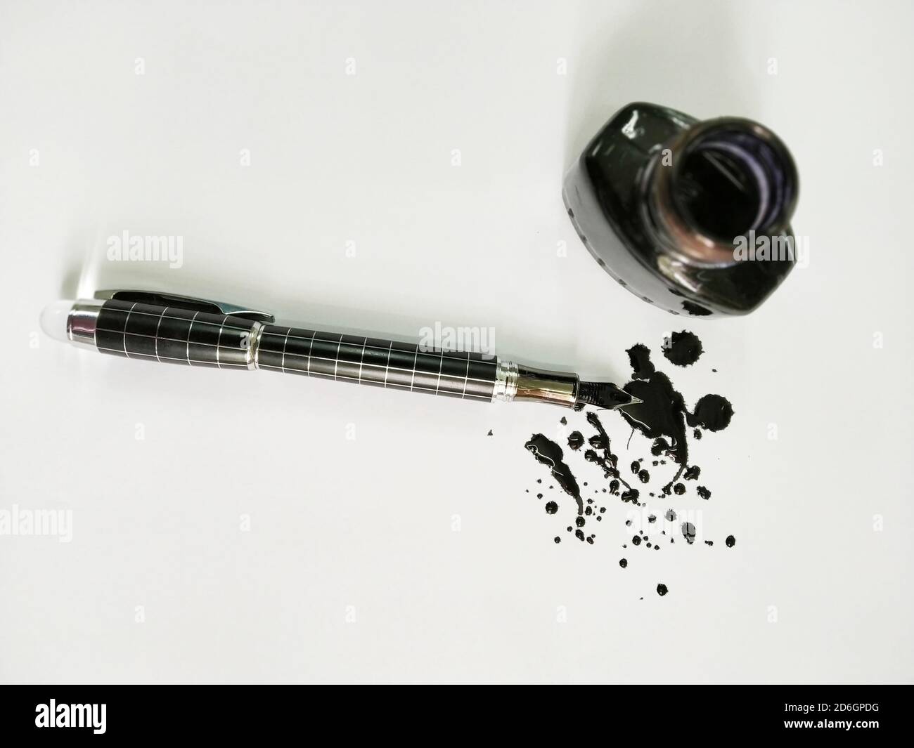 A Ink pen with black ink spread on paper and a ink bottle Stock Photo ...