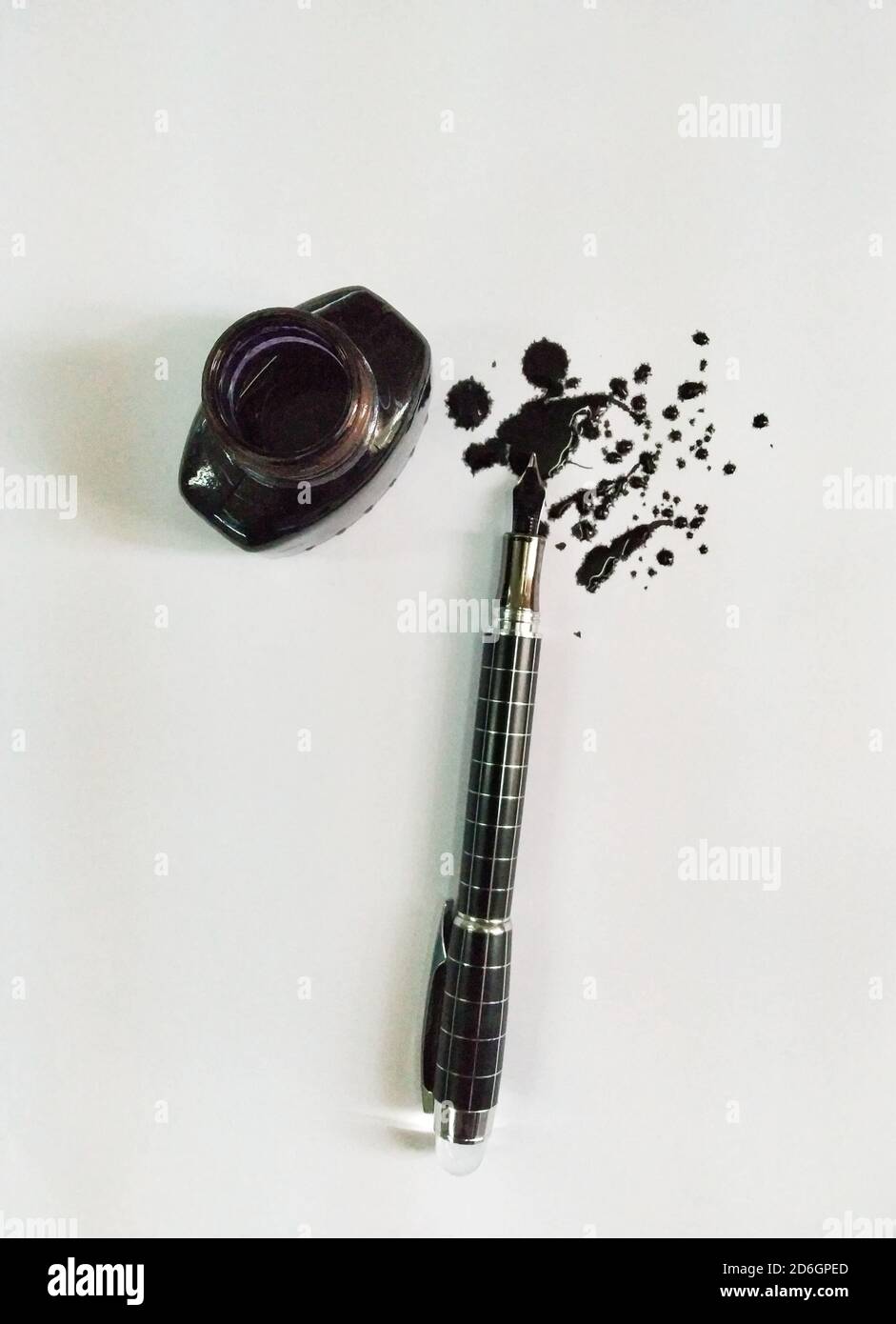 A Ink pen with black ink spread on paper and a ink bottle Stock Photo ...