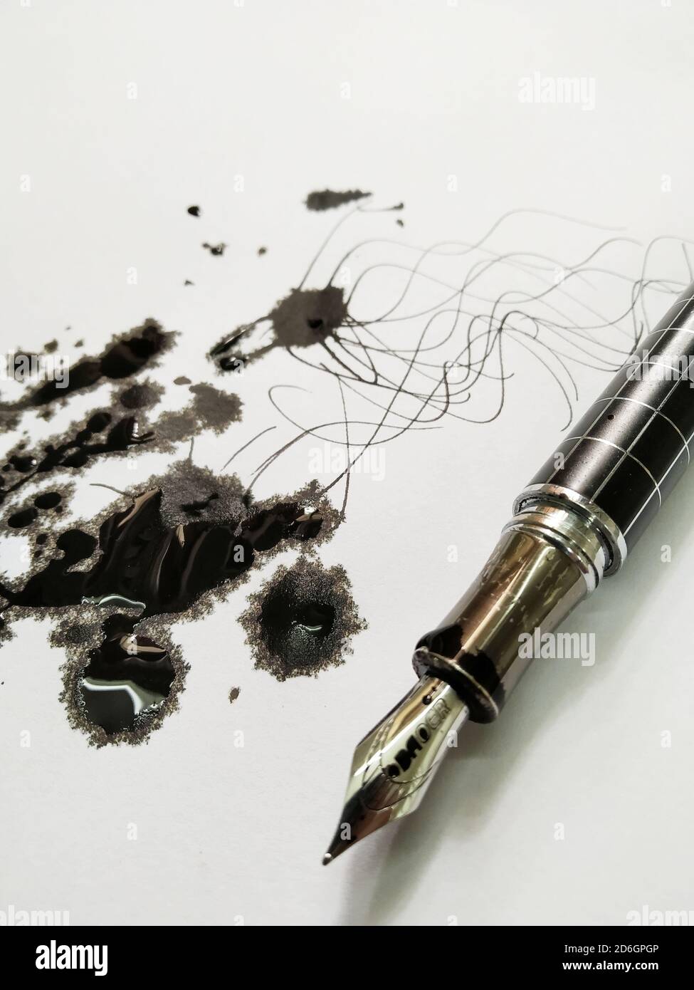 A Ink pen with black ink spread on paper Stock Photo - Alamy