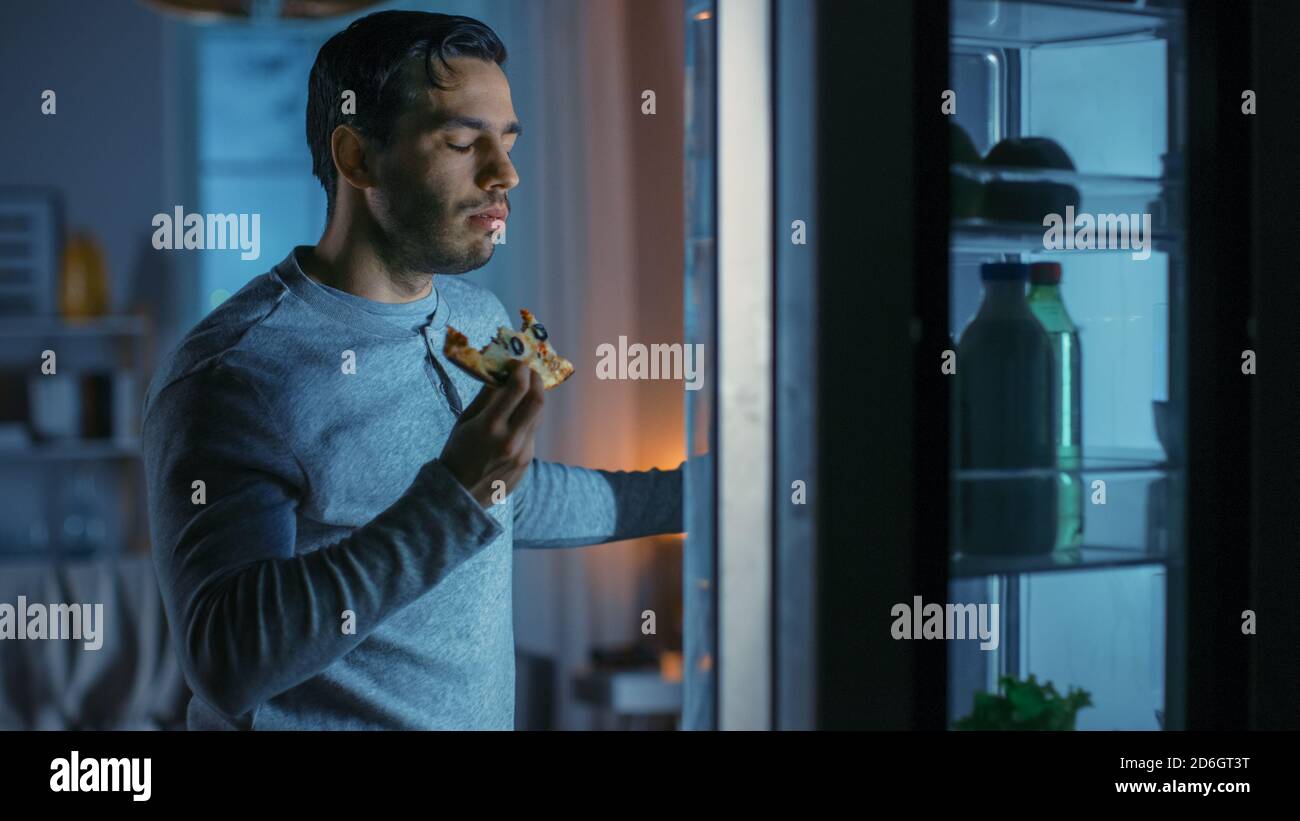 At Night in the Kitchen Handsome Attractive Young Man is Eating a ...