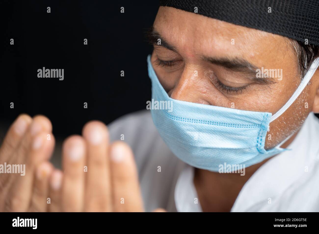 High angle view close up shot of muslim man in medical mask preforming ...