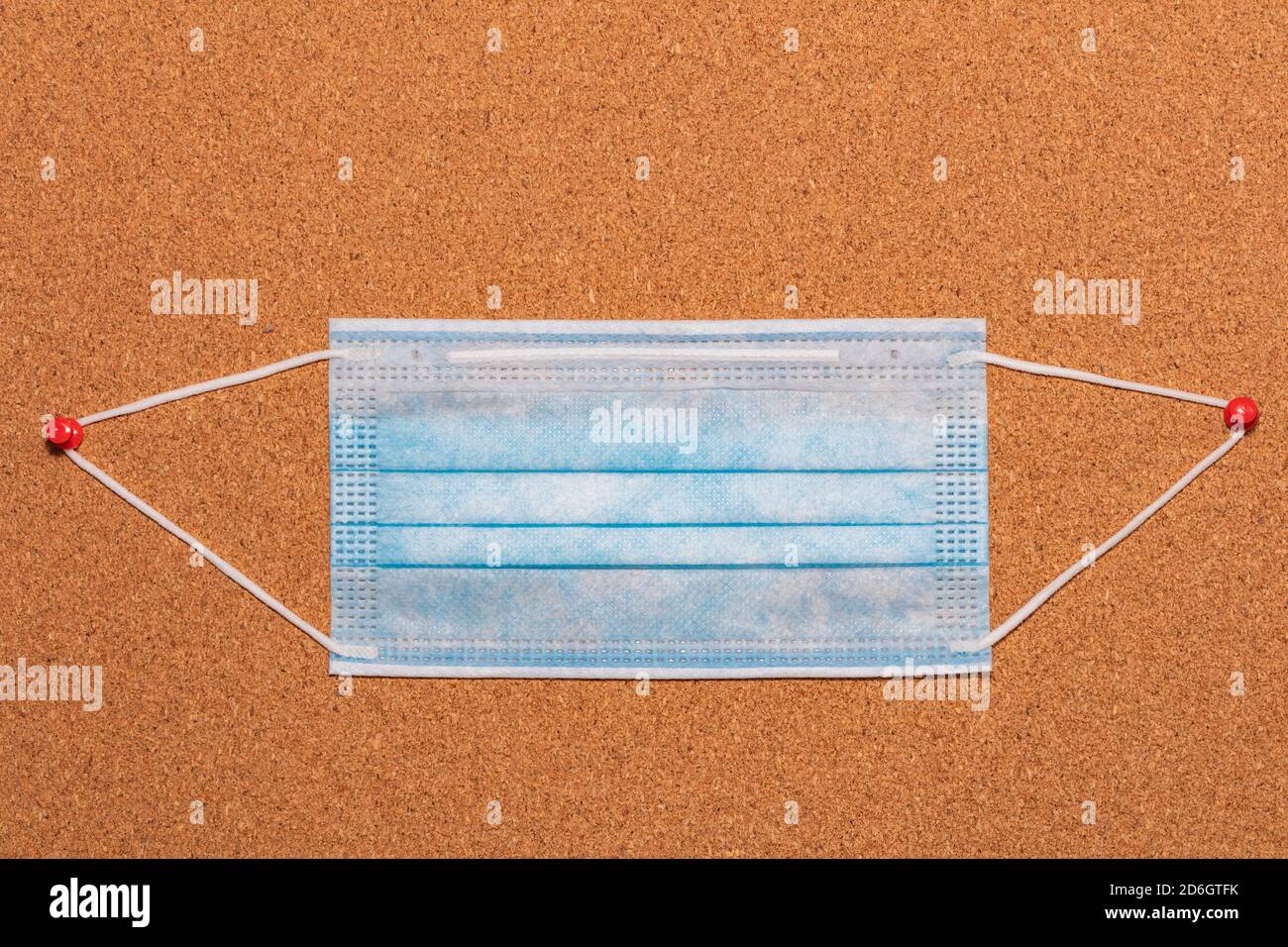 Medical mask pinned on a corkwood notice board. Healthcare concept ...