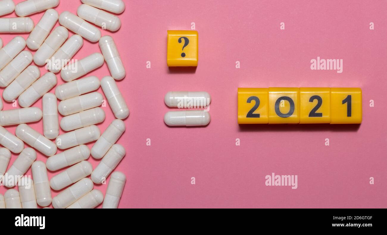 Top view of white pills equal 2021 and question mark sign above the ...