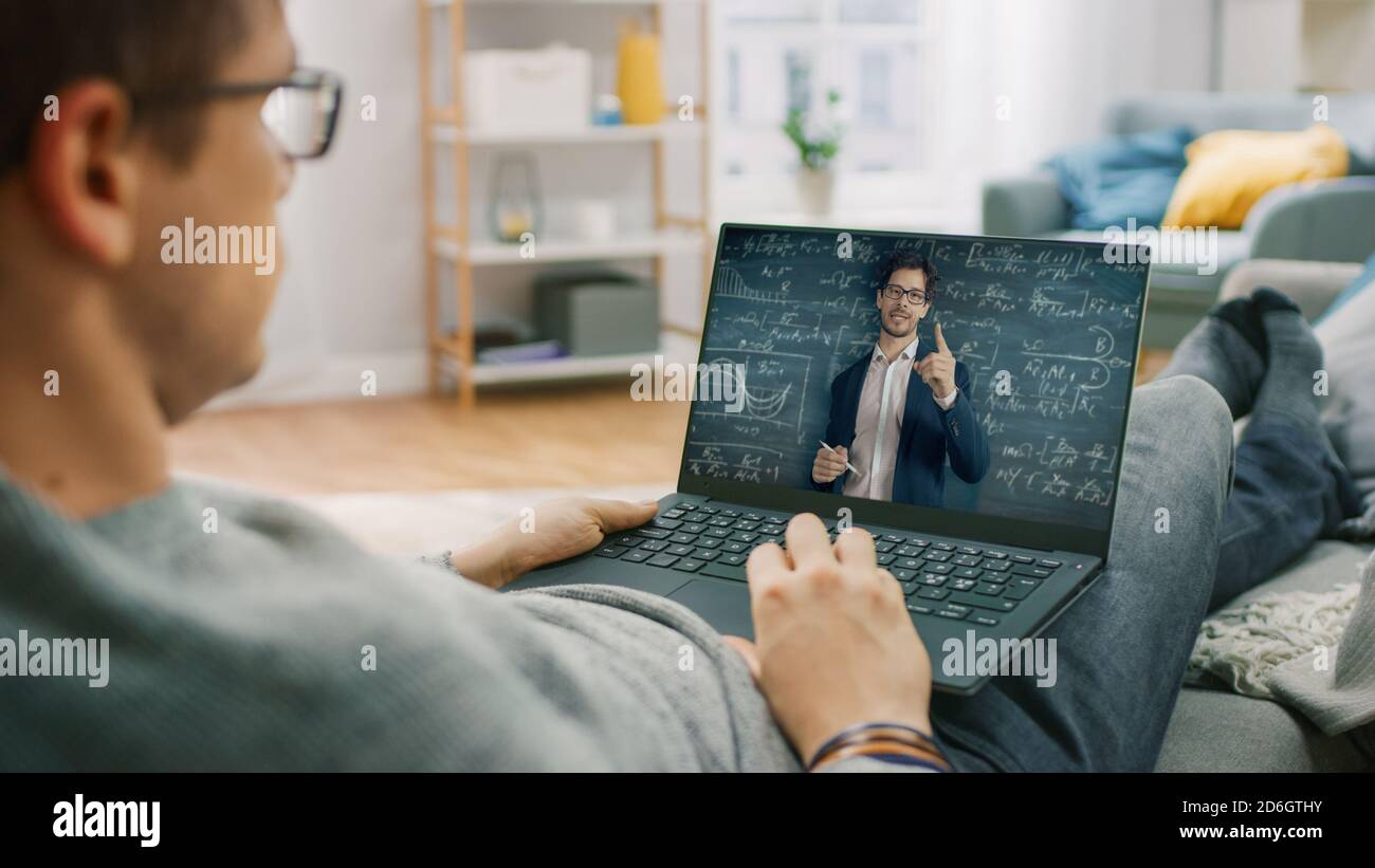 Man at Home Sitting on a Couch Using Laptop Computer for Video Call to ...