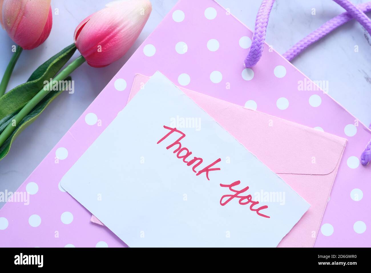 thank you message on sticky note with tulip flower on pink background ...