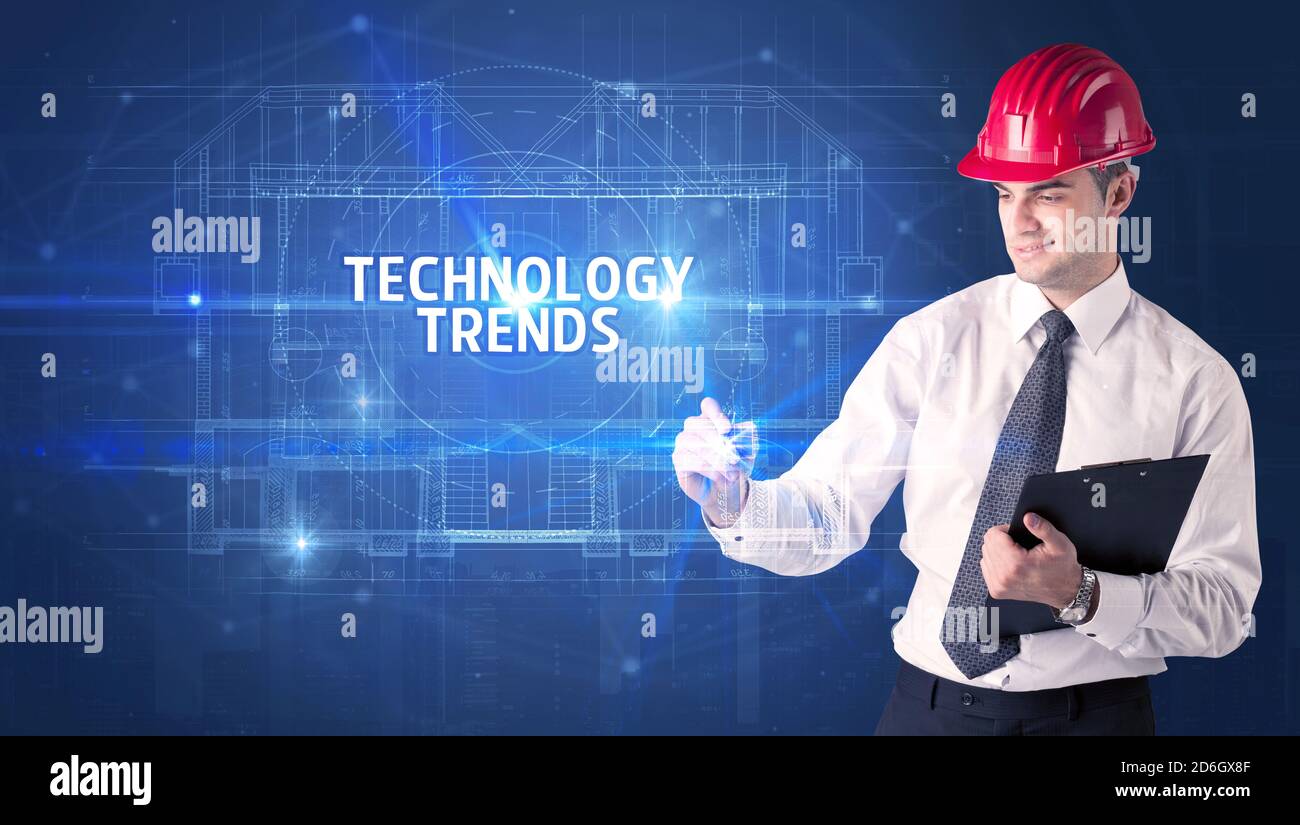 Handsome architect with helmet drawing TECHNOLOGY TRENDS inscription ...