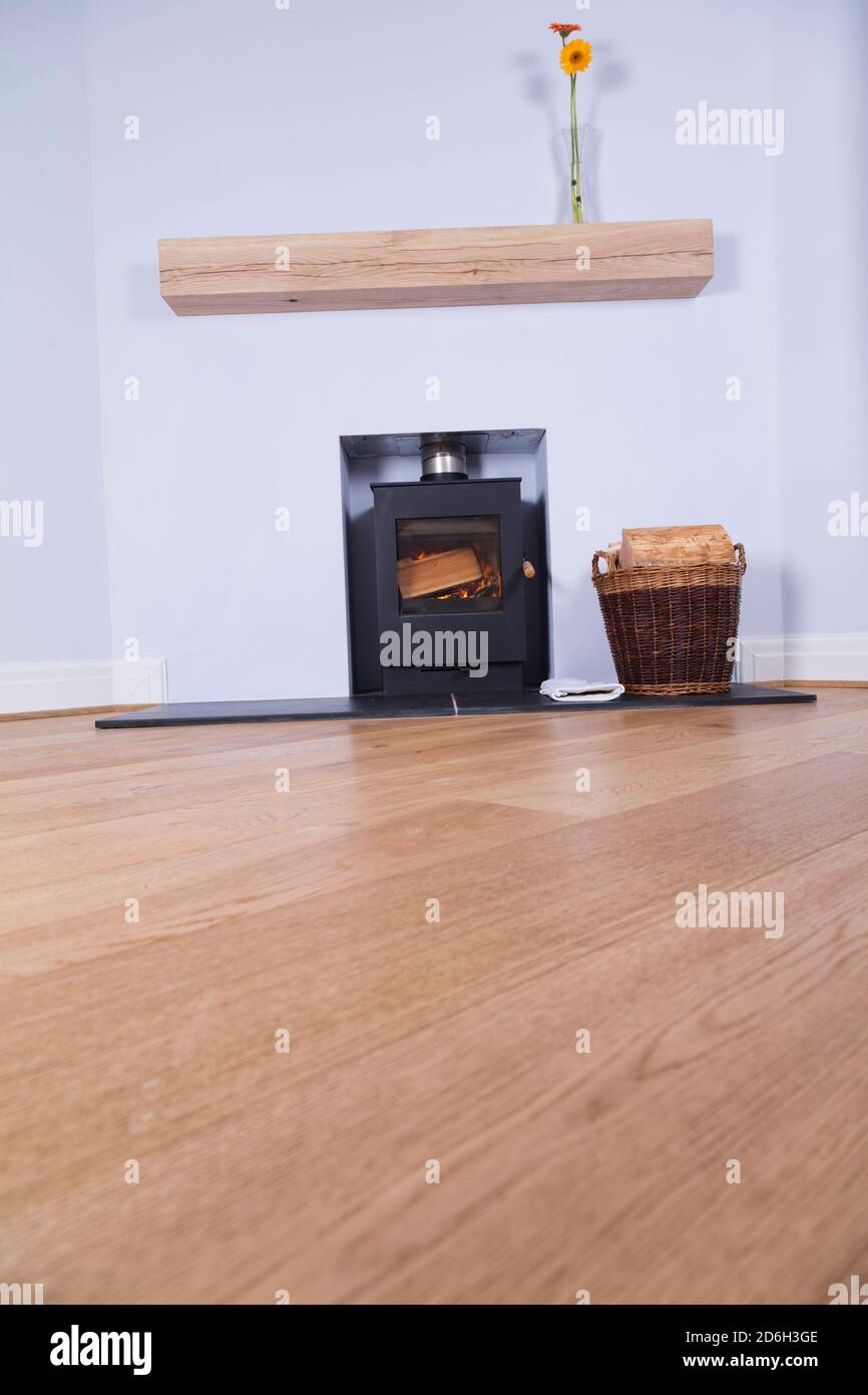 Woodburning stove with an oak mantel above it in a modern home Stock ...