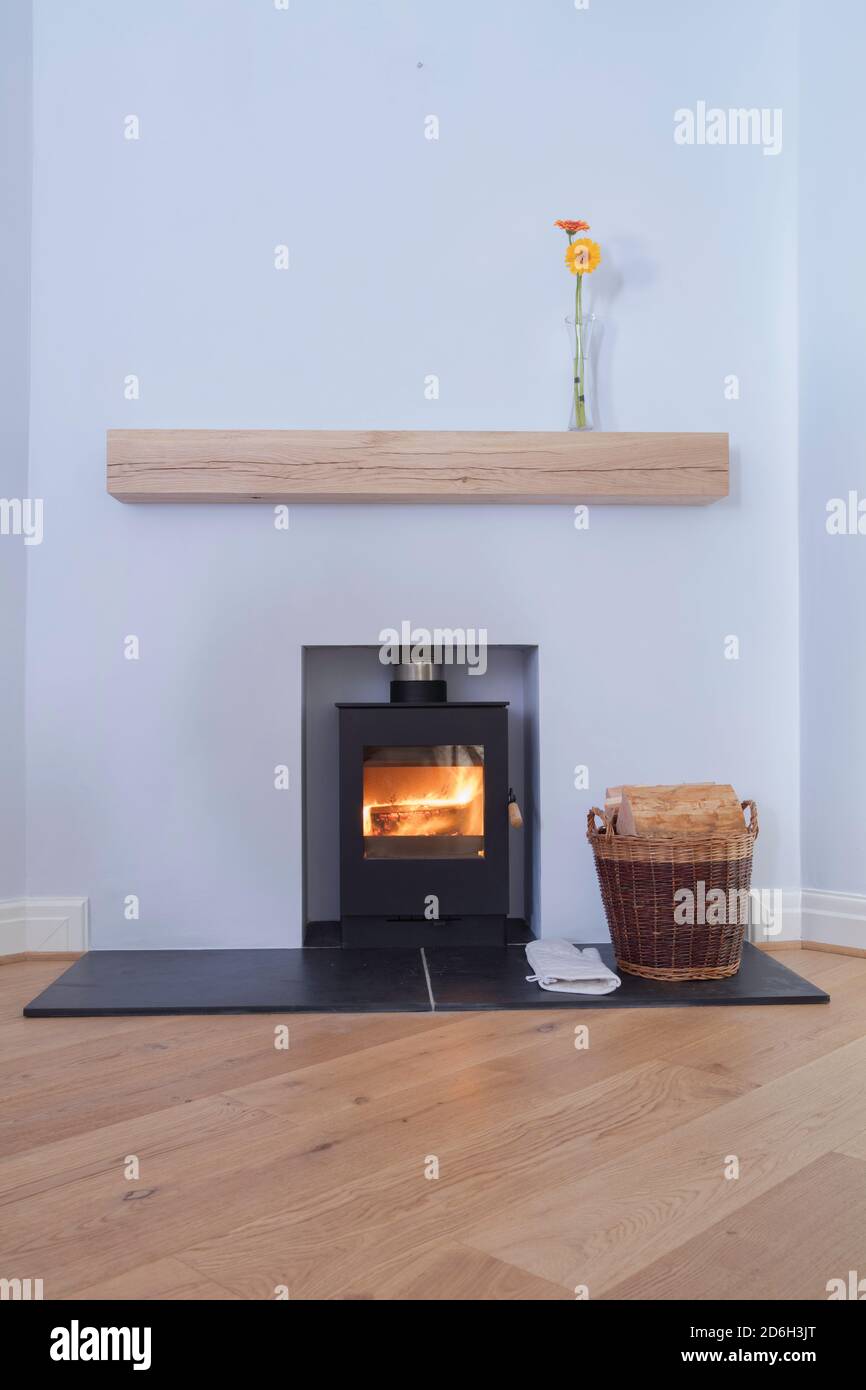 Woodburning stove with an oak mantel above it in a modern home Stock ...