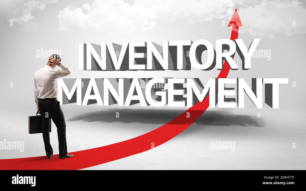 Rear view of a businessman standing in front of INVENTORY MANAGEMENT ...