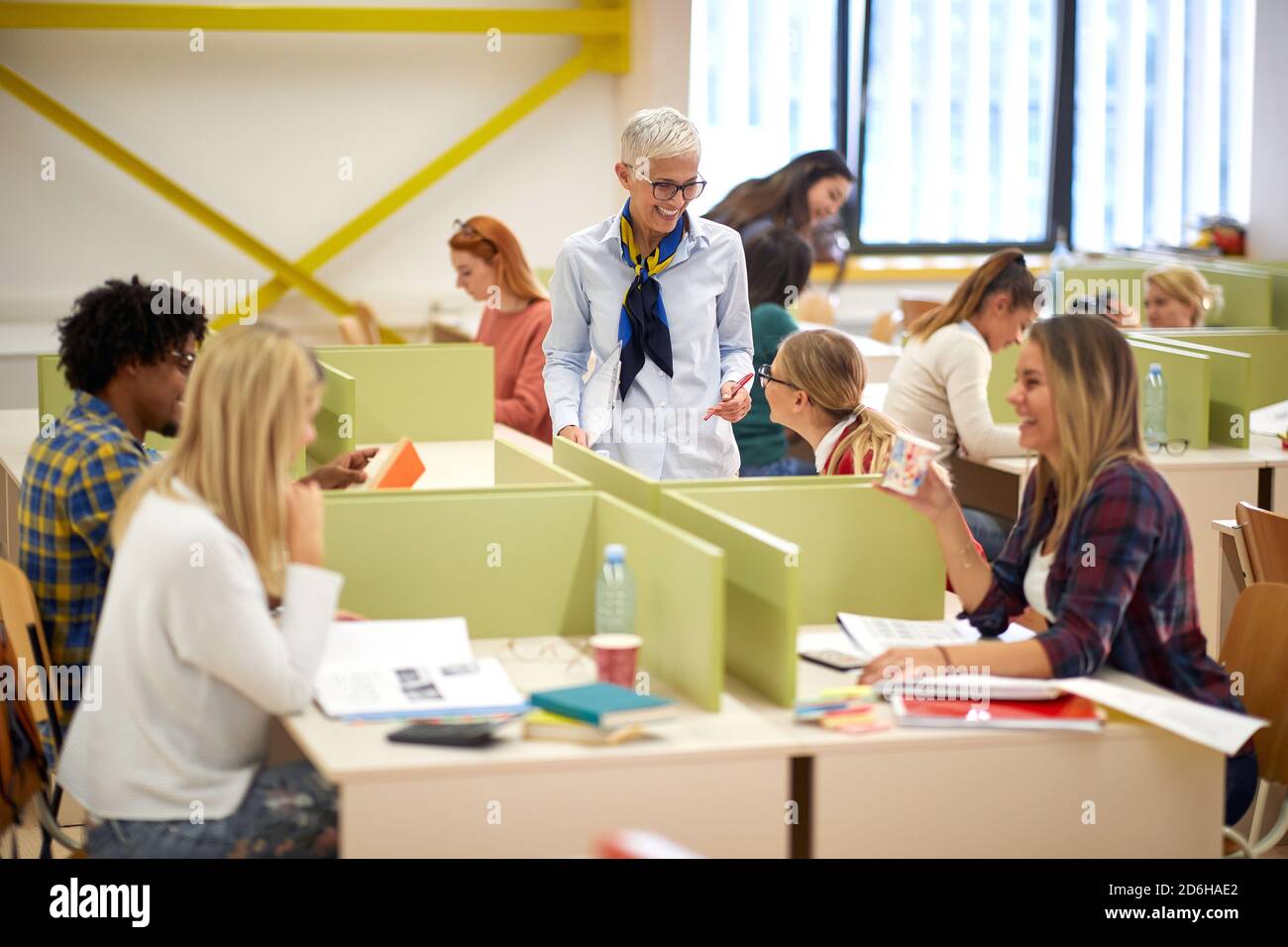 Female professor discussing a lesson with students at a lecture in a ...