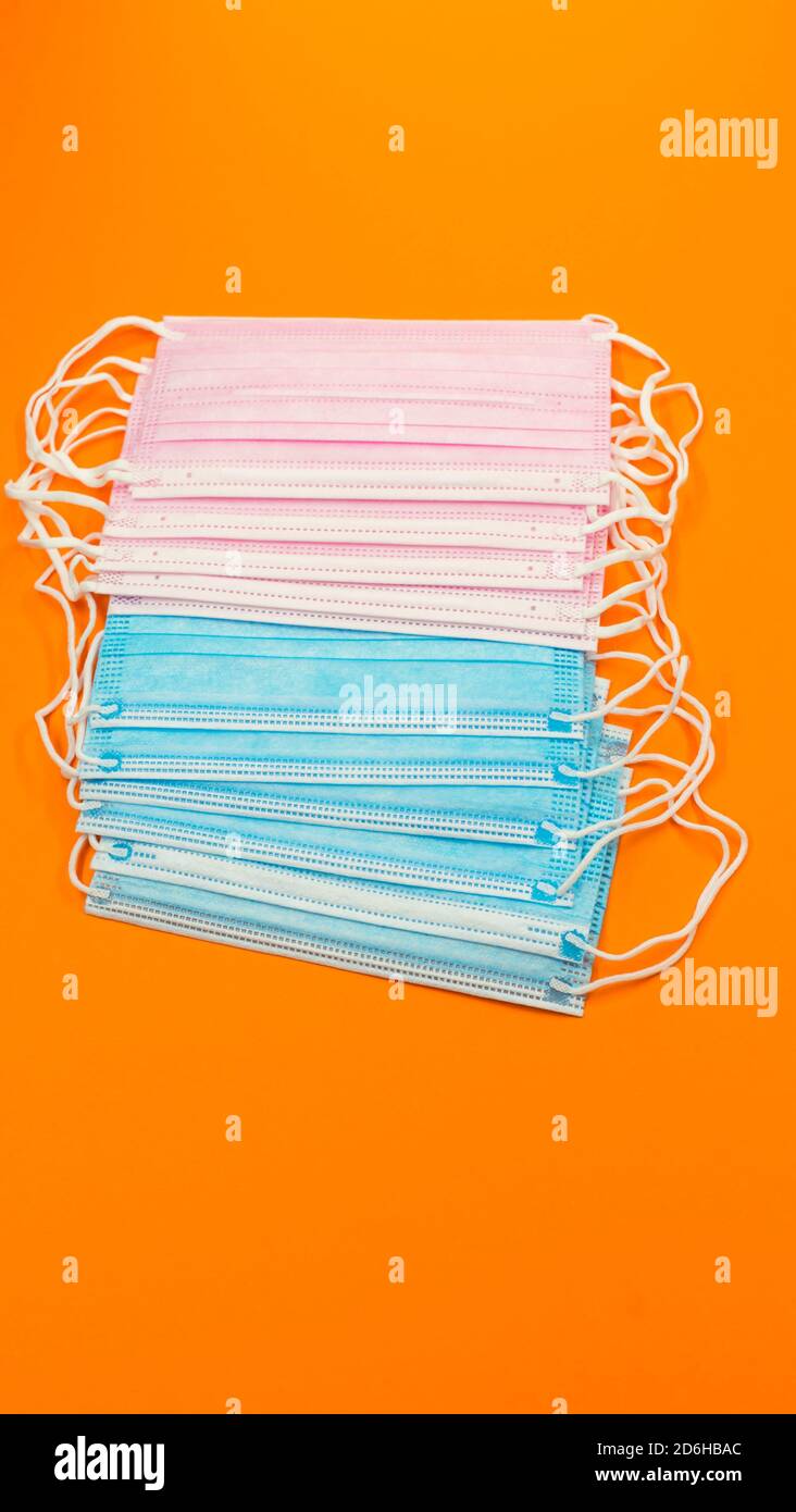 Vertical shot of surgical masks on an orange surface Stock Photo - Alamy