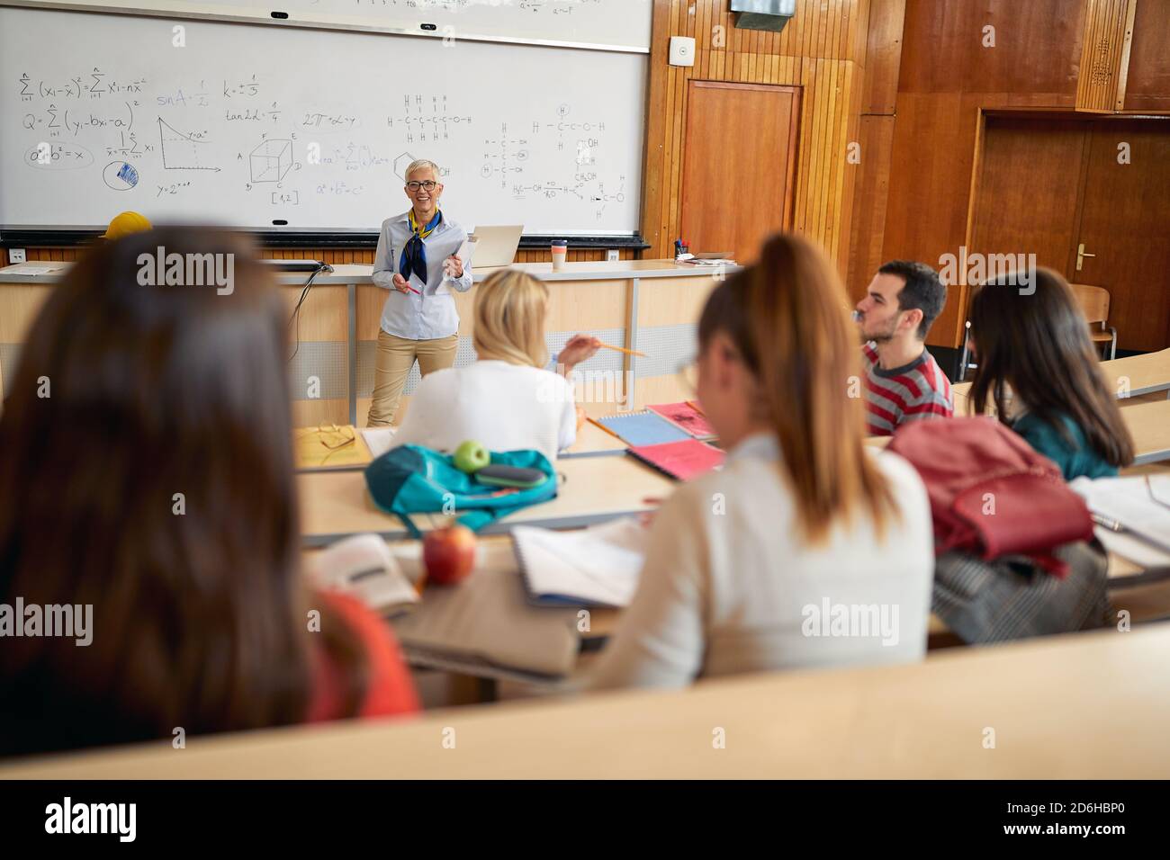 A female professor giving a lecture to students in the university ...