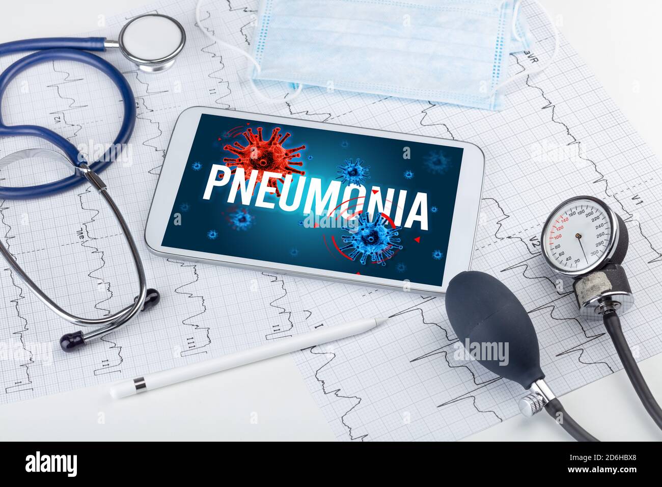 Tablet pc and doctor tools on white surface with PNEUMONIA inscription ...