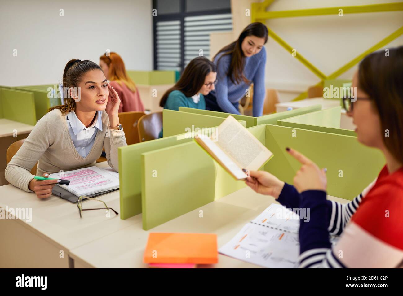 Female student colleagues discussing a lesson in the university ...