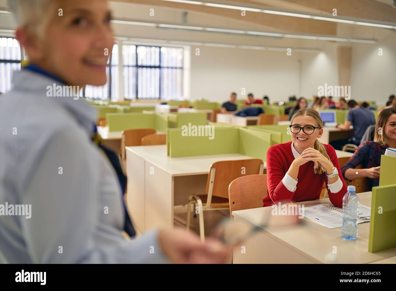 A female professor and students at the lecture in an educational ...