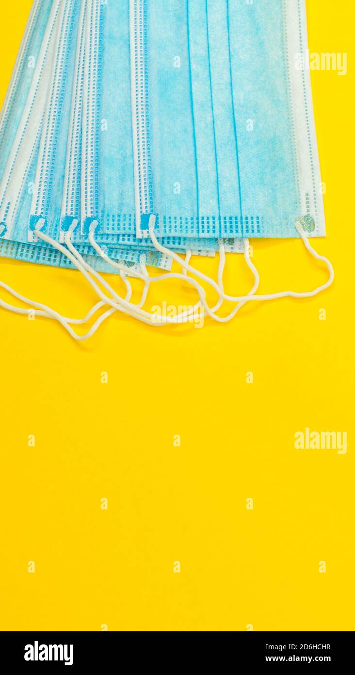 Vertical shot of surgical masks on a yellow surface Stock Photo - Alamy