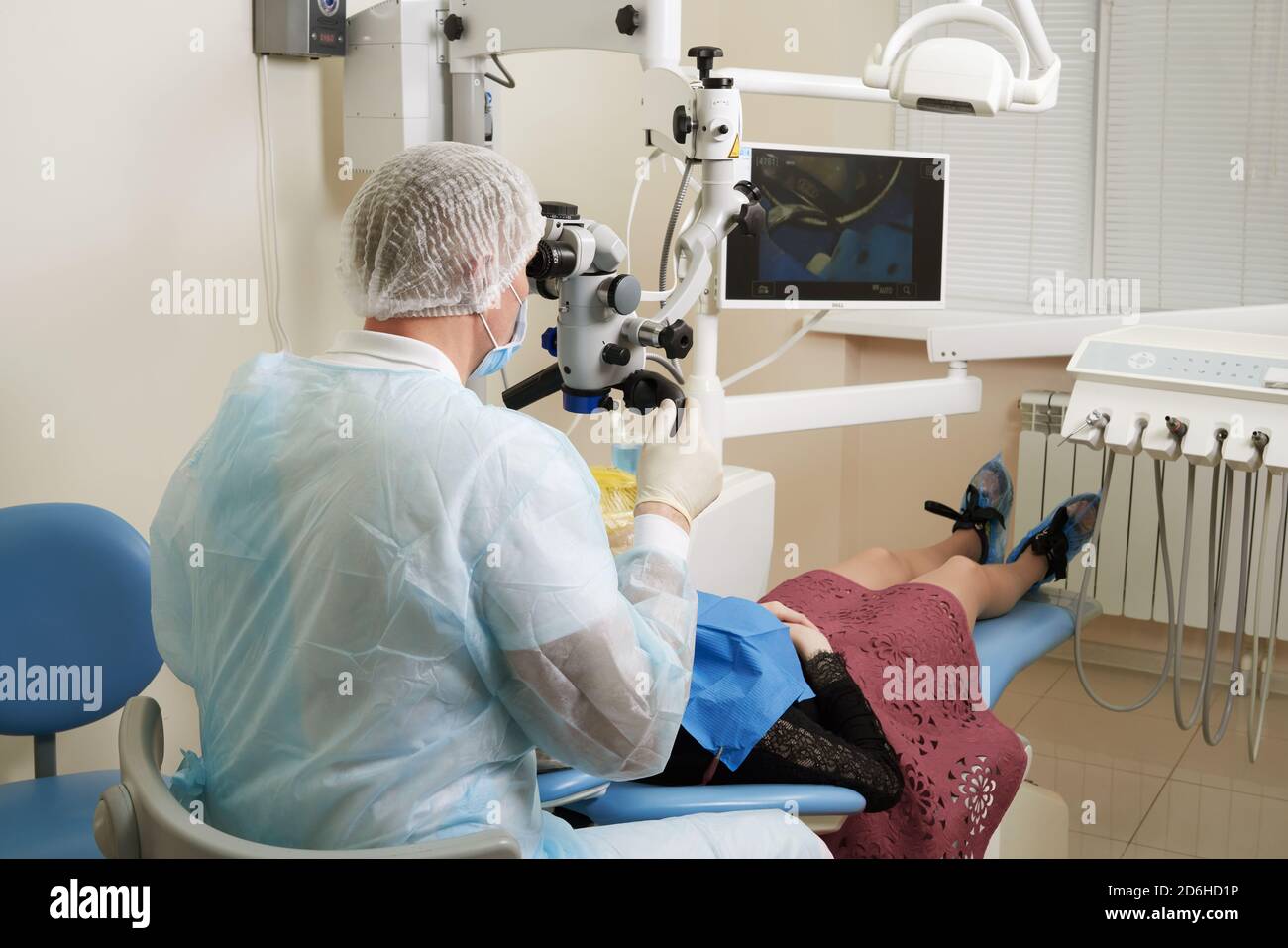 Dentist working with dental microscope and patient at modern dentist ...