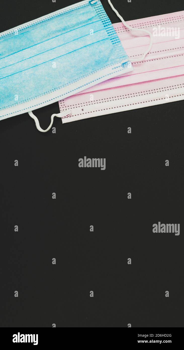 Vertical shot of surgical masks on a black surface Stock Photo - Alamy