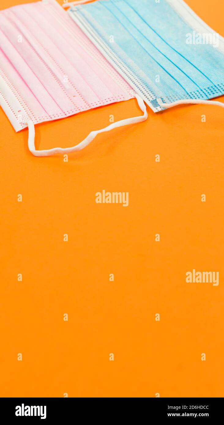 Vertical shot of surgical masks on an orange surface Stock Photo - Alamy