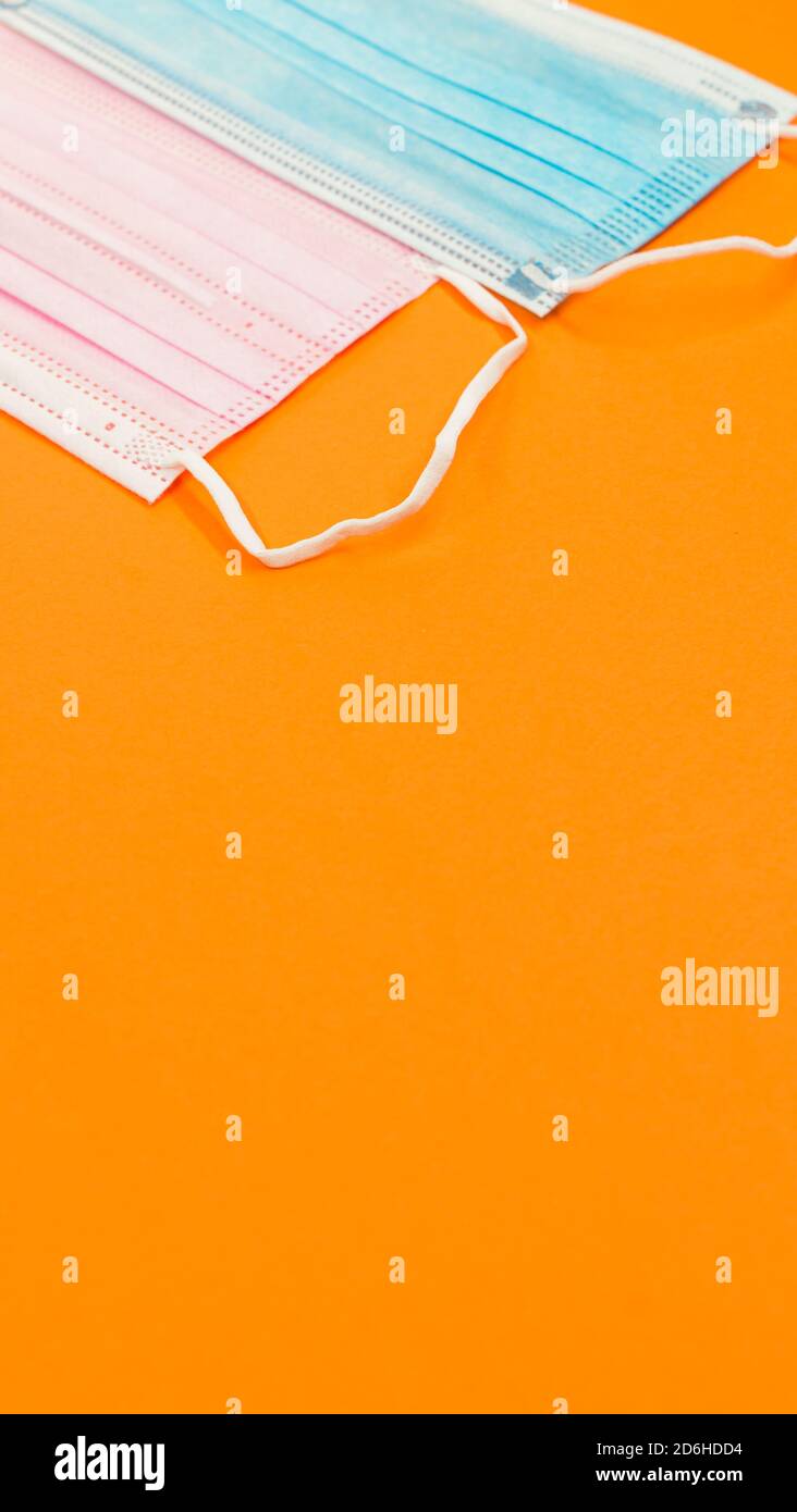 Vertical shot of surgical masks on an orange surface Stock Photo - Alamy