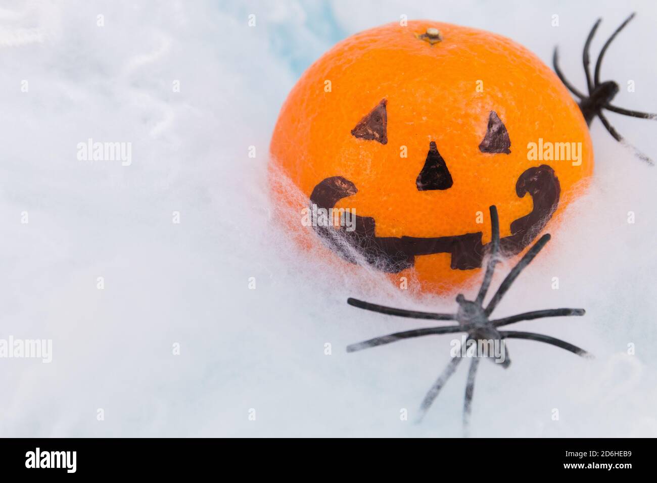Bright orange Halloween scary tangerine emotion face on white spider ...