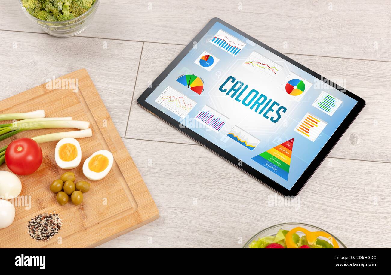 Organic food and tablet pc showing CALORIES inscription, healthy ...
