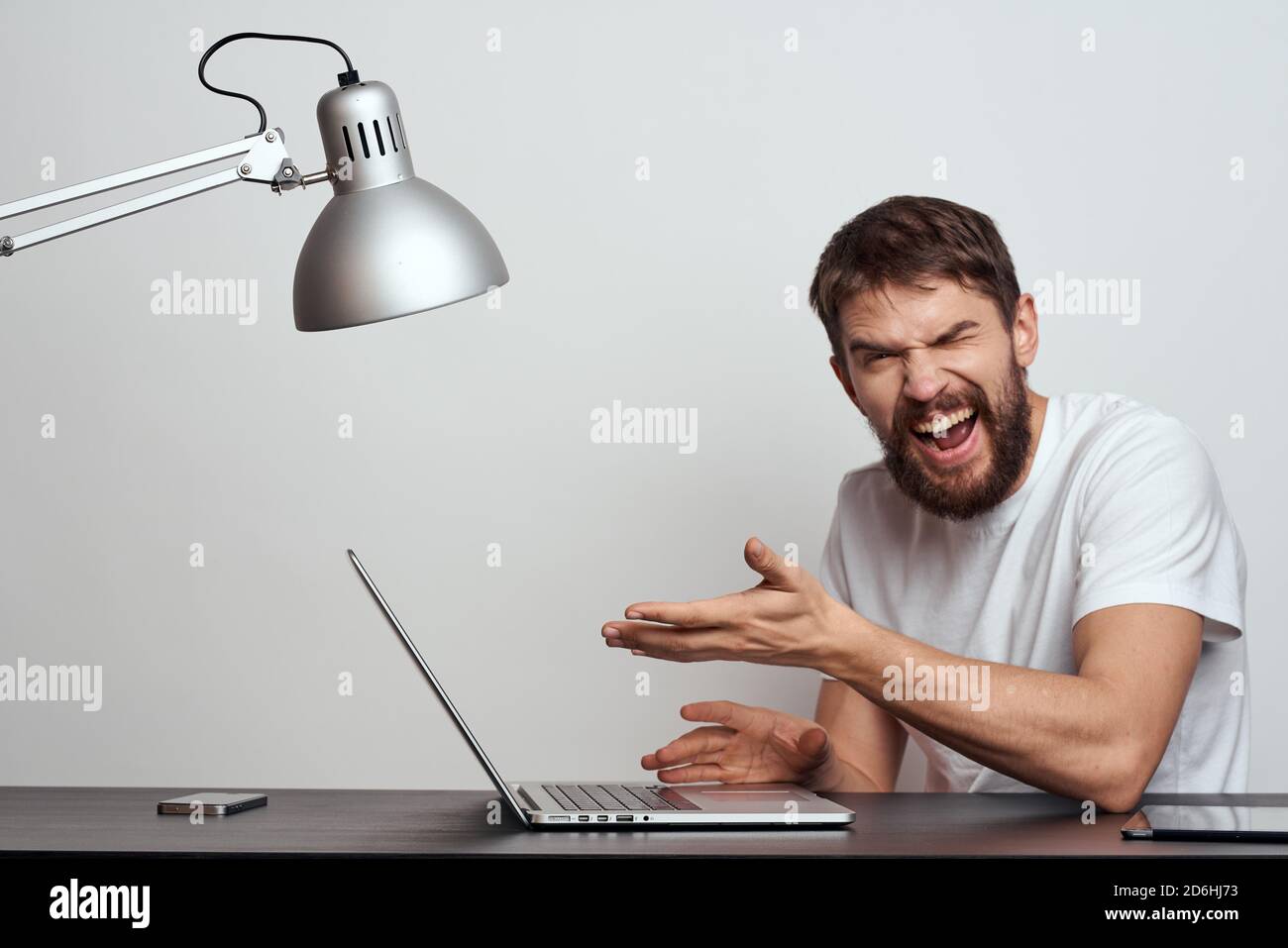 Business man with laptop at the table gestures with hands monitor ...